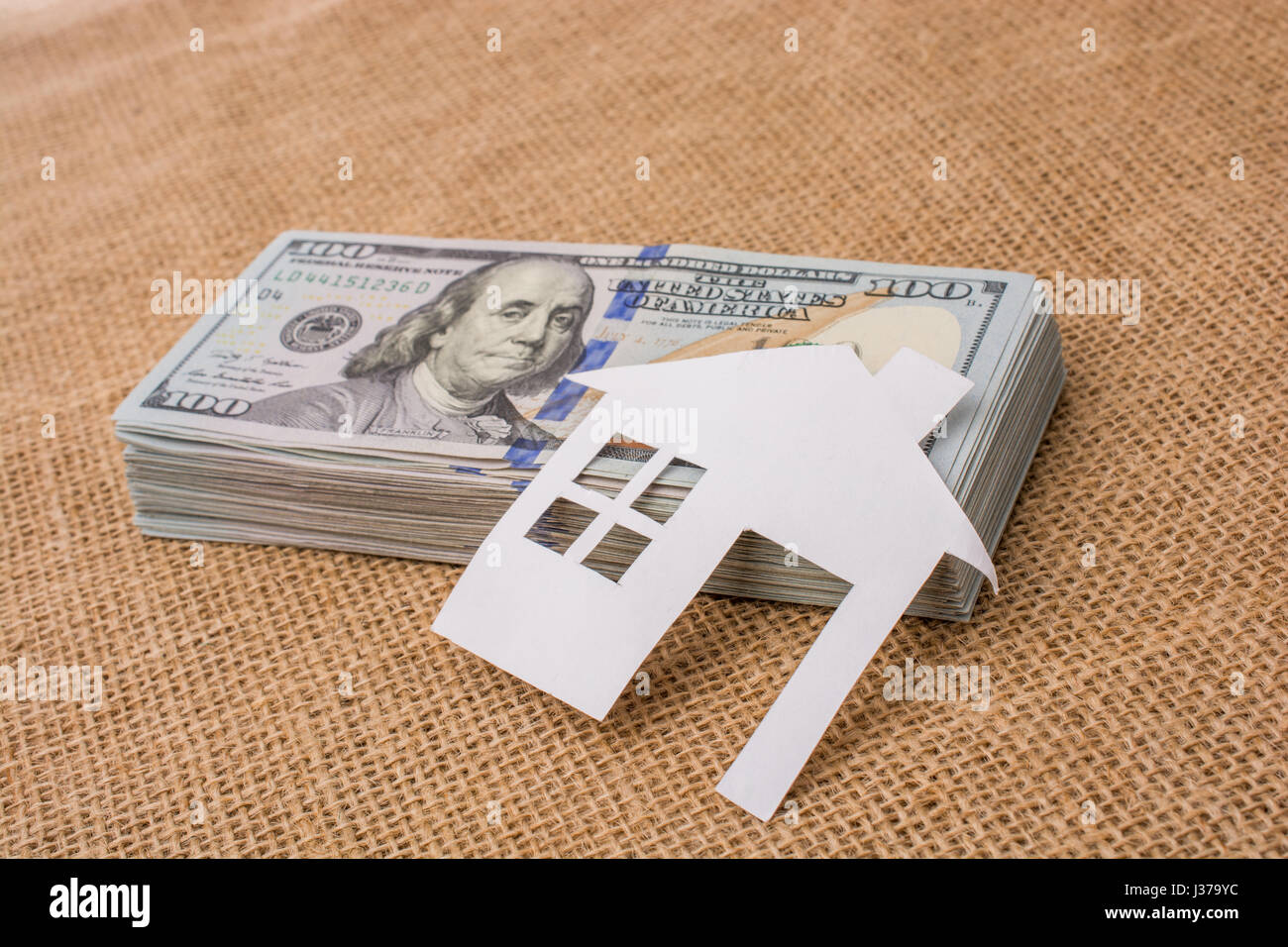 Paper house placed beside a bundle of US dollar banknote Stock Photo ...