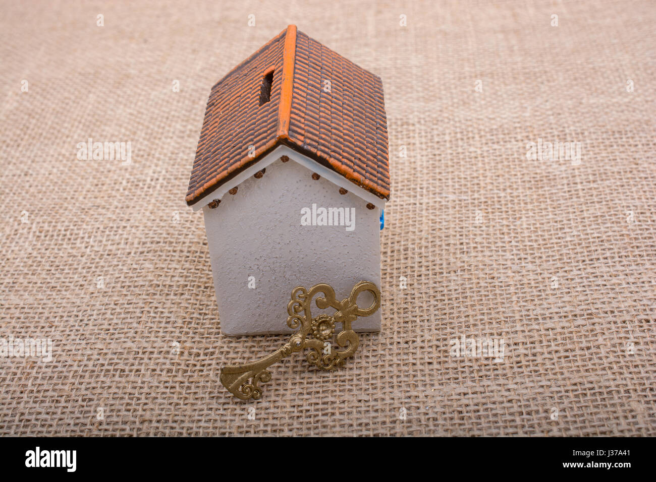 Retro key on a model house on a brown color background Stock Photo - Alamy