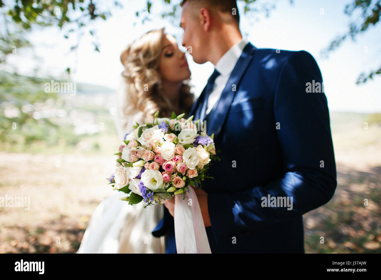 Happy wedding couple in love near trees on sunny day Stock Photo - Alamy