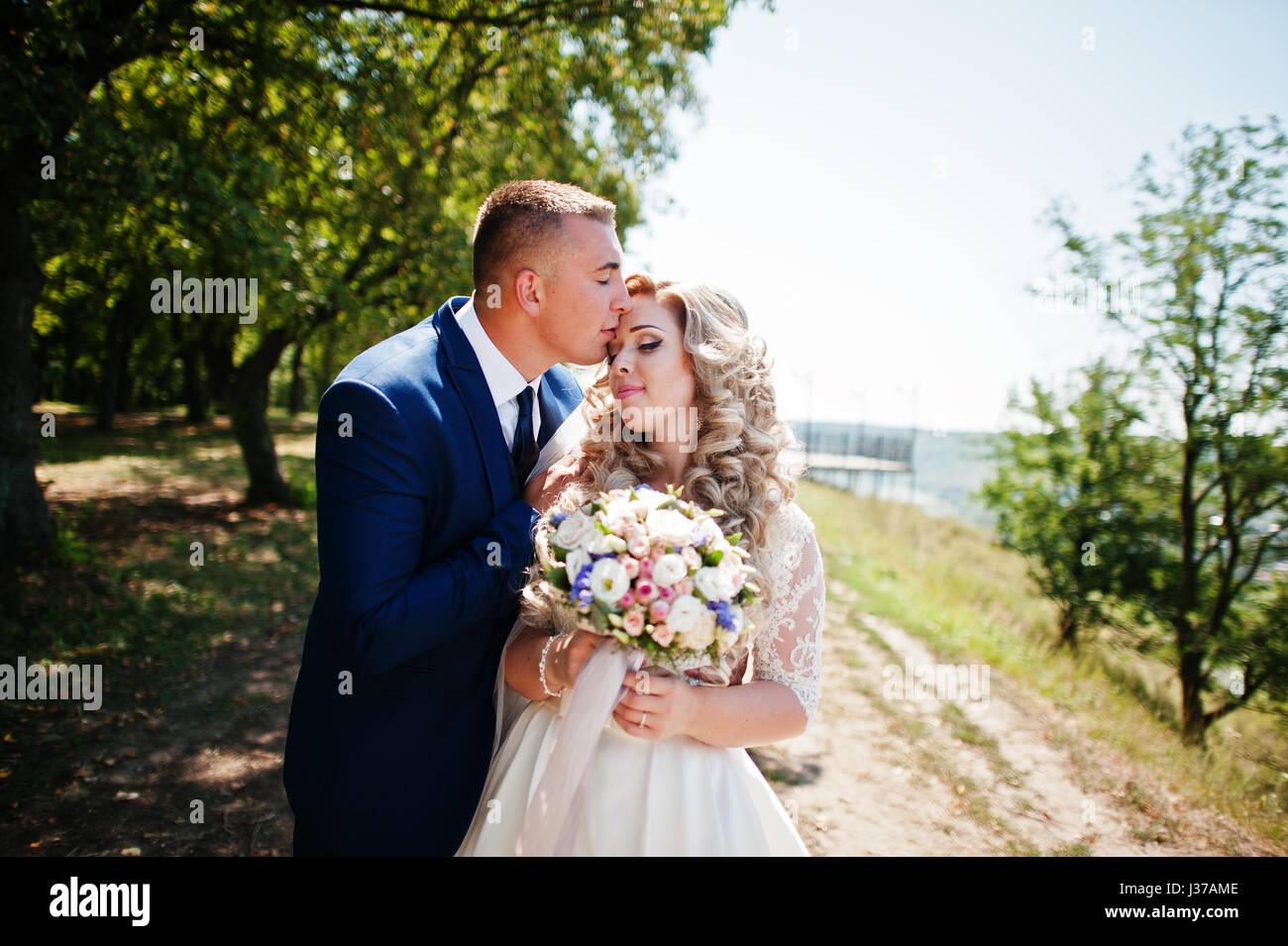 Happy wedding couple in love near trees on sunny day Stock Photo - Alamy