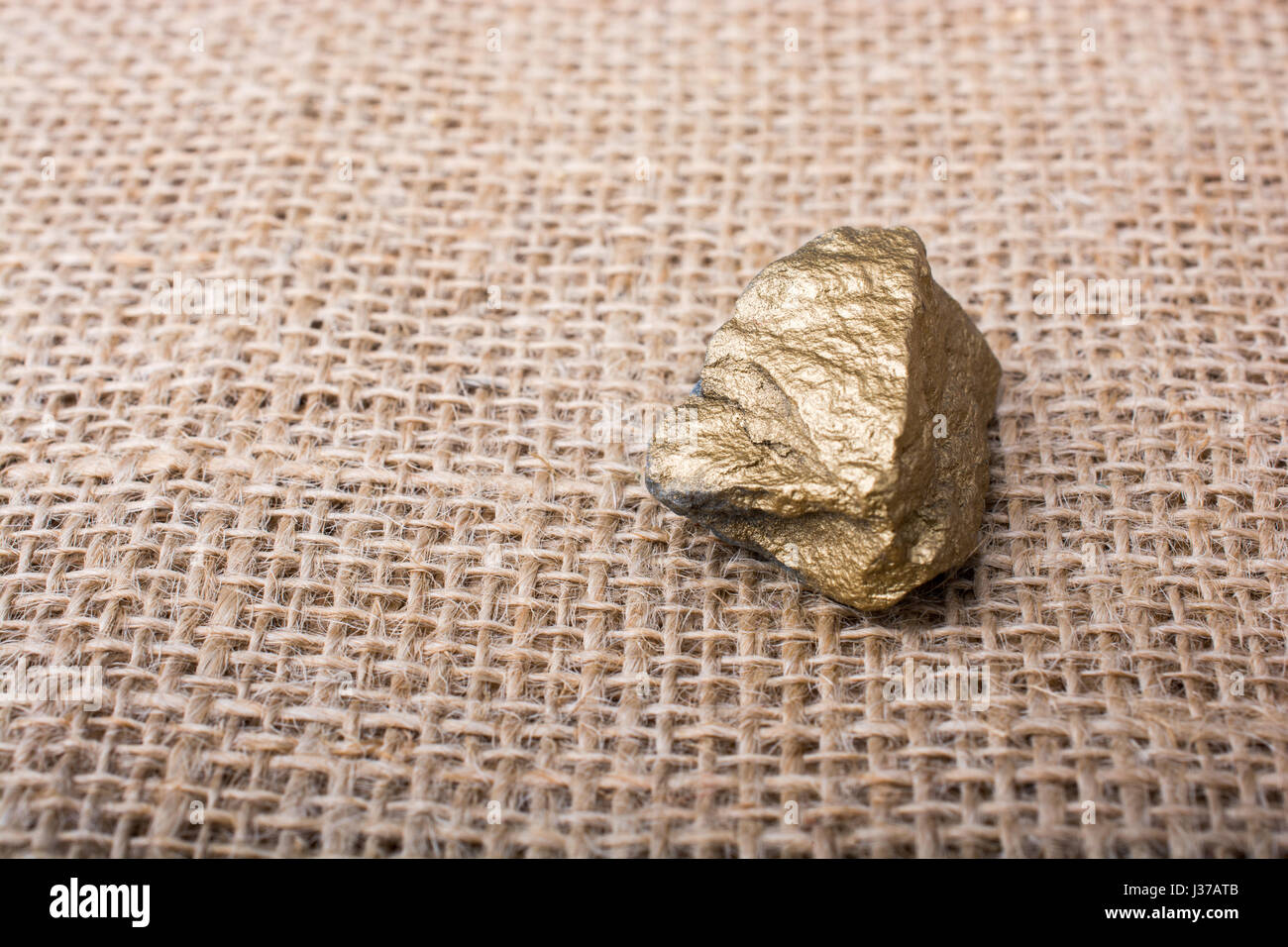 little gold color stone on a linen canvas Stock Photo - Alamy