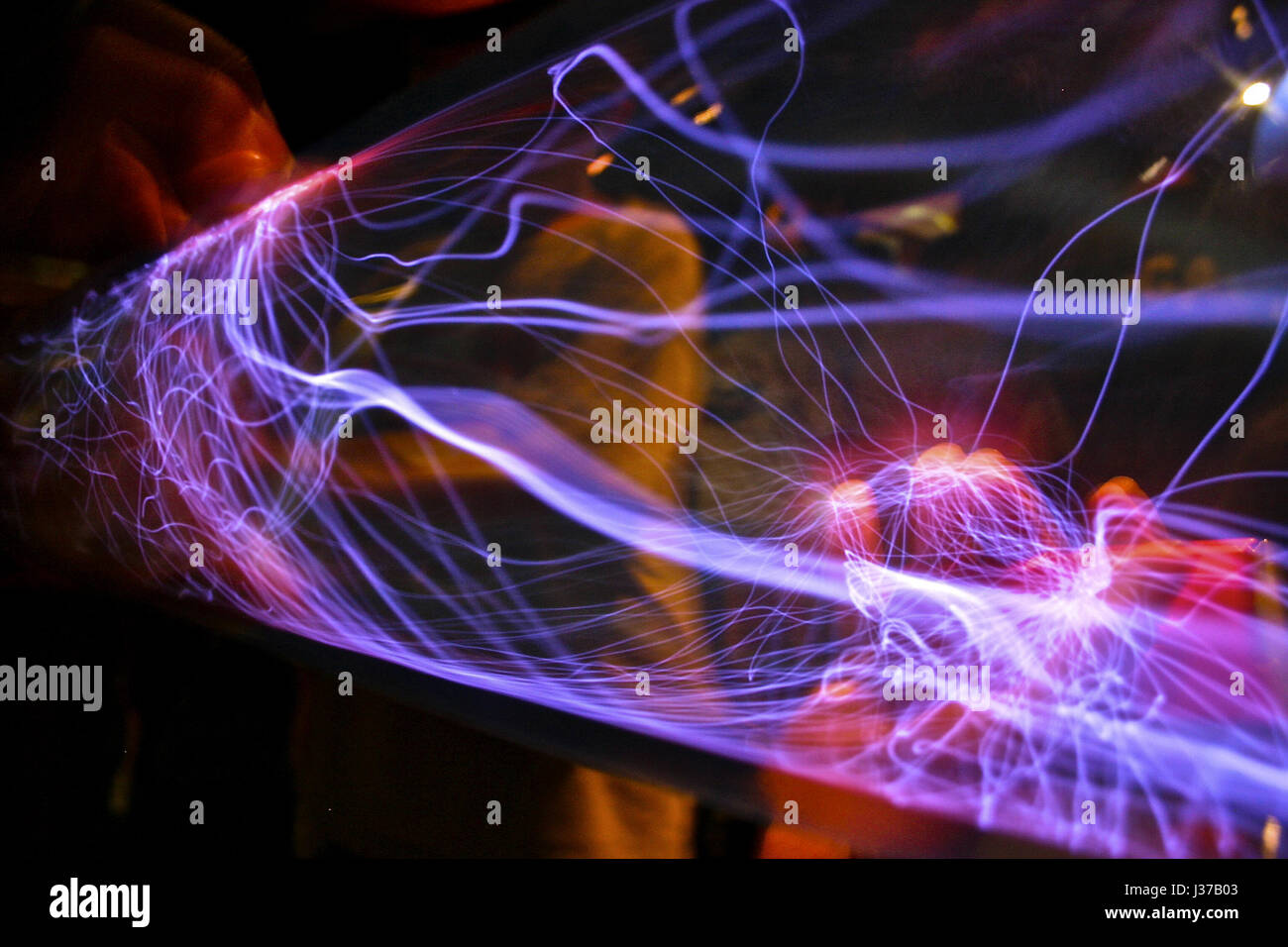 Museum visitors touch a plasma tube, which sets off beautiful ...