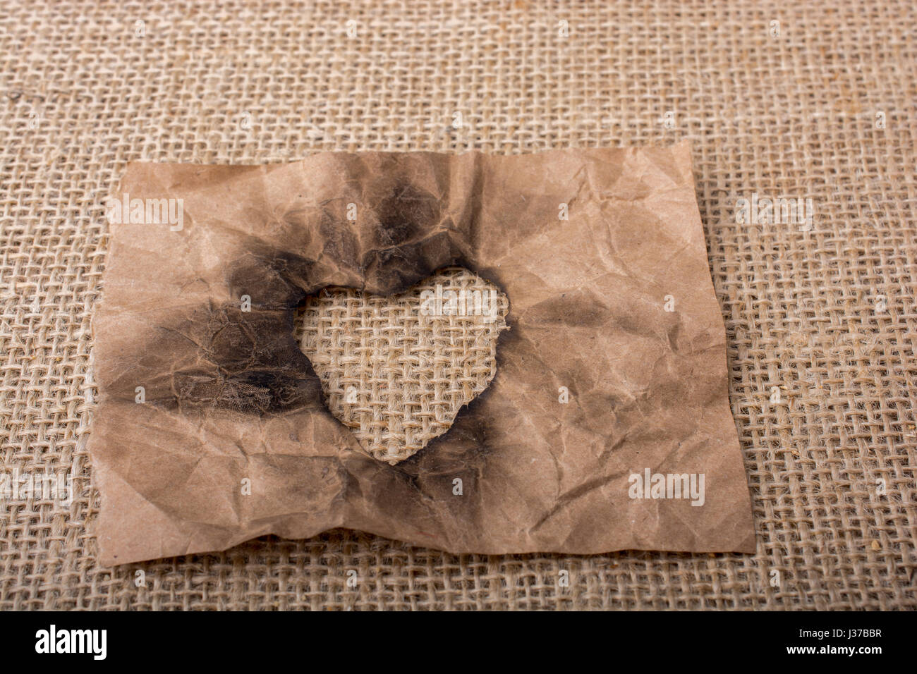 Heart shaped burnt out of a brown paper Stock Photo - Alamy