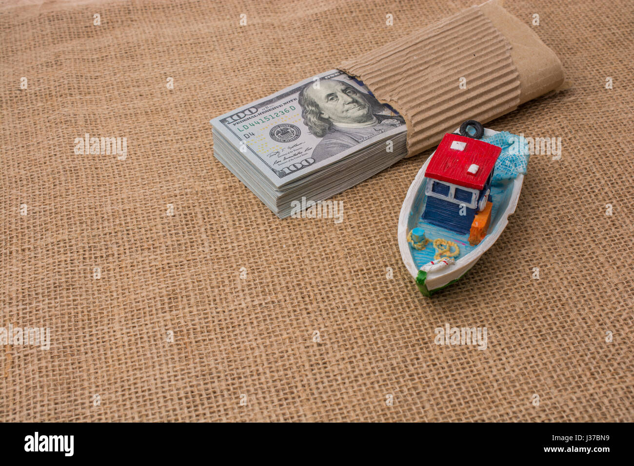 Model boat and banknote bundle of US dollar on canvas Stock Photo - Alamy