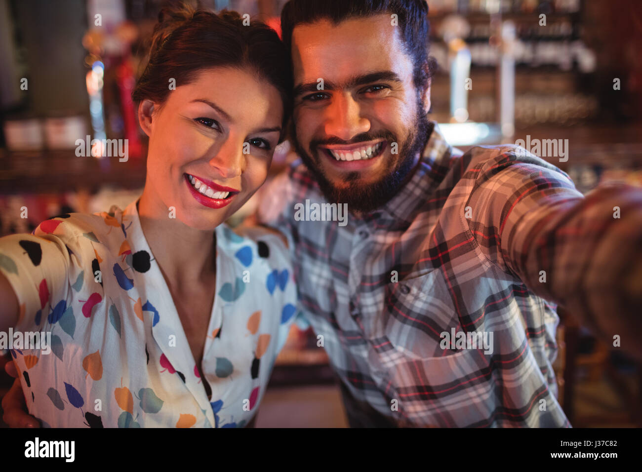 Portrait of smiling couple having fun in pub Stock Photo - Alamy