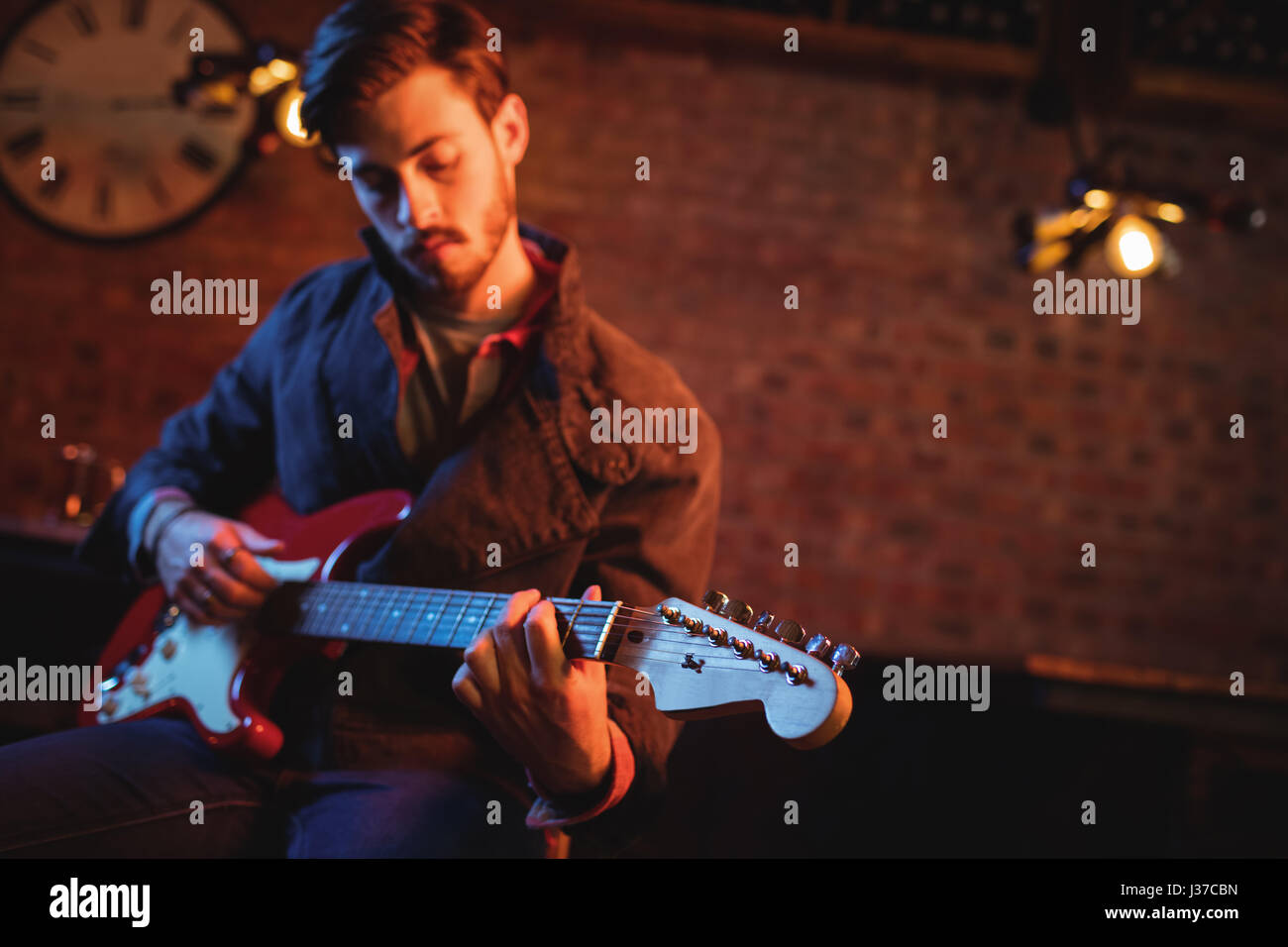 Young man playing guitar in pub Stock Photo - Alamy