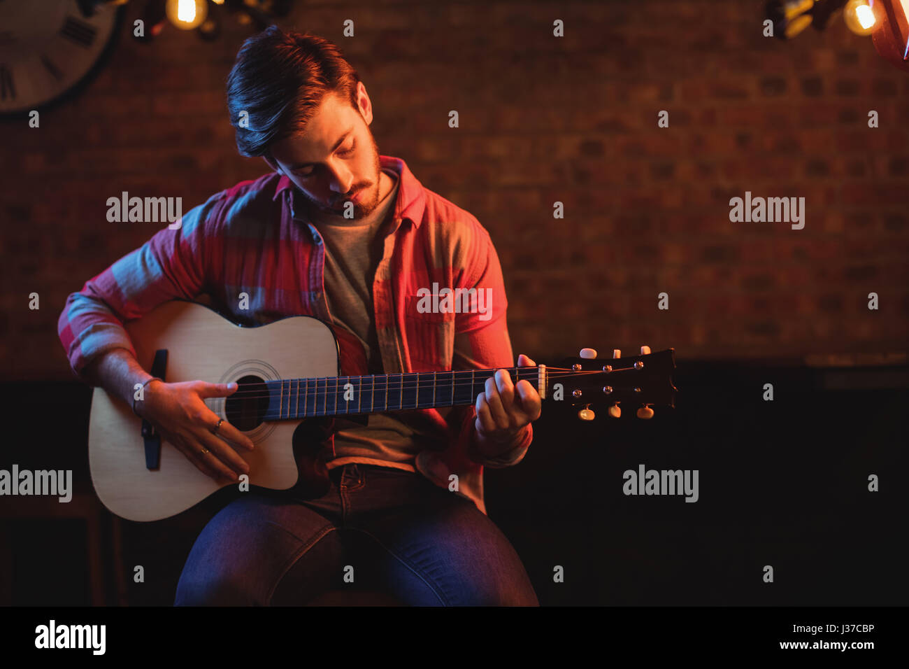 Young man playing guitar in pub Stock Photo - Alamy