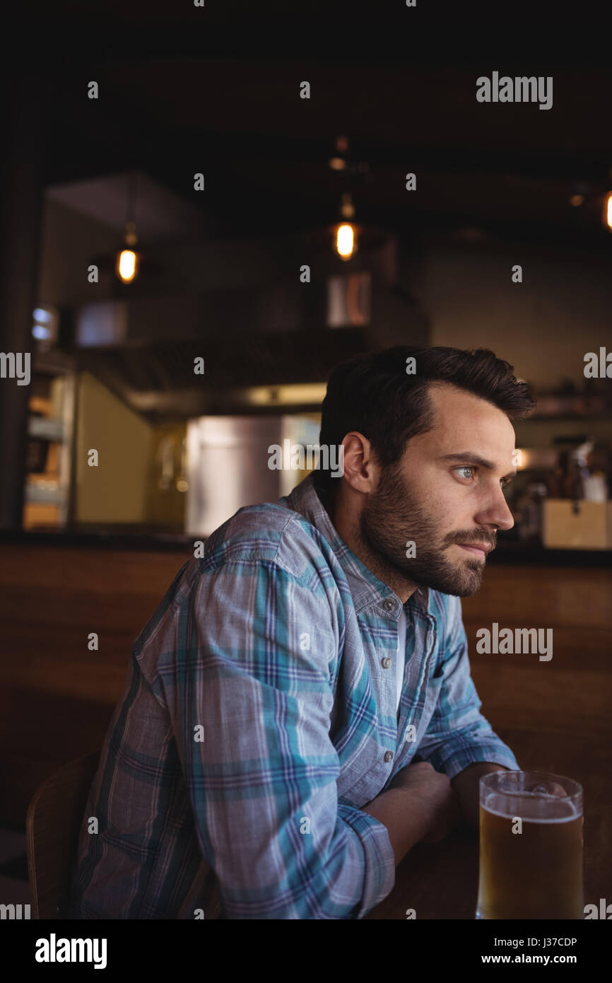 Thoughtful man having beer in bar Stock Photo - Alamy