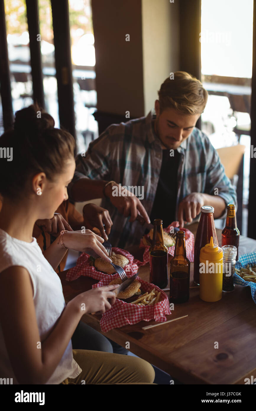 Friends having burger together at restaurant Stock Photo - Alamy