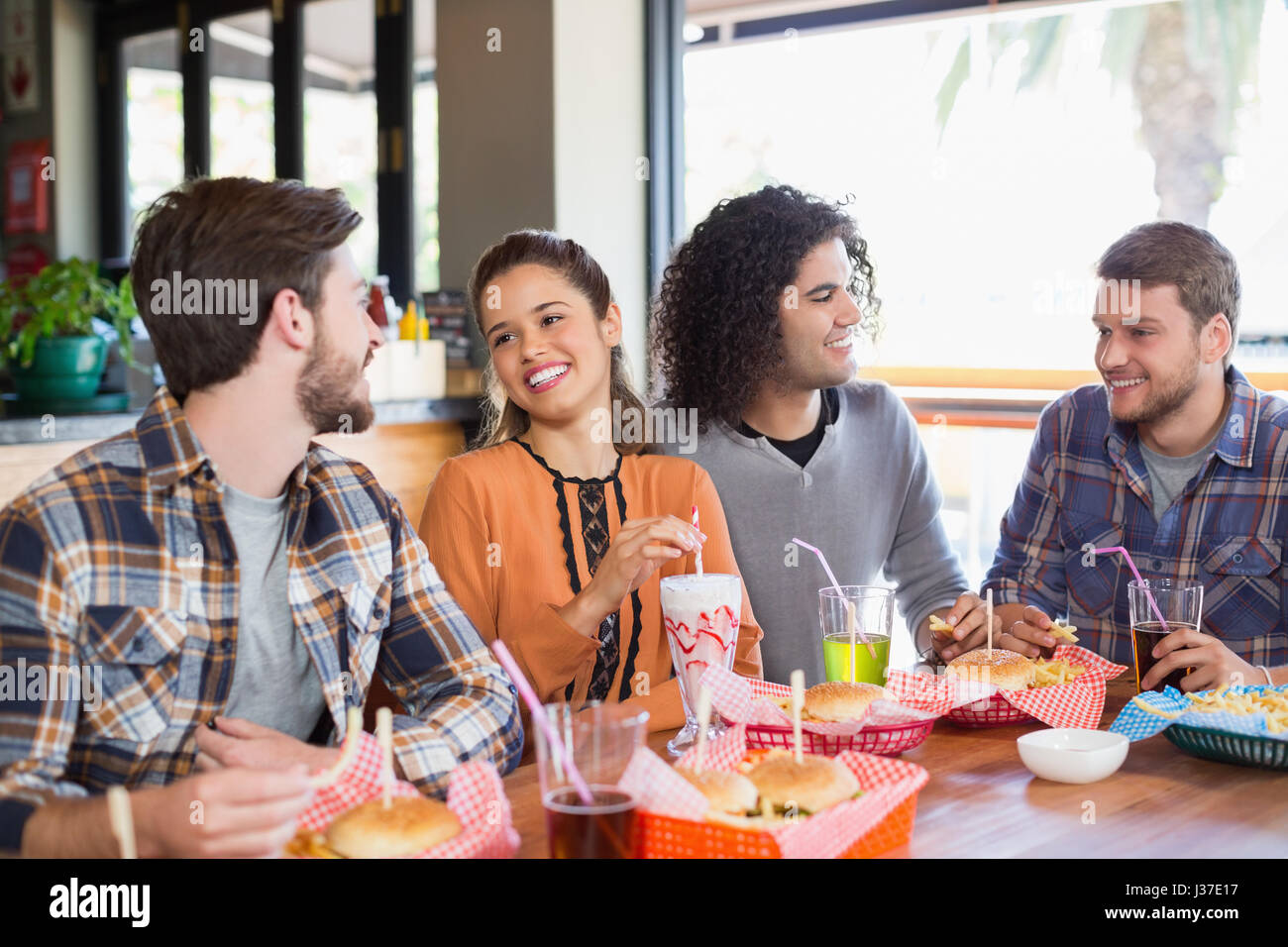 Group of friends talking while having lunch in restaurant Stock Photo ...