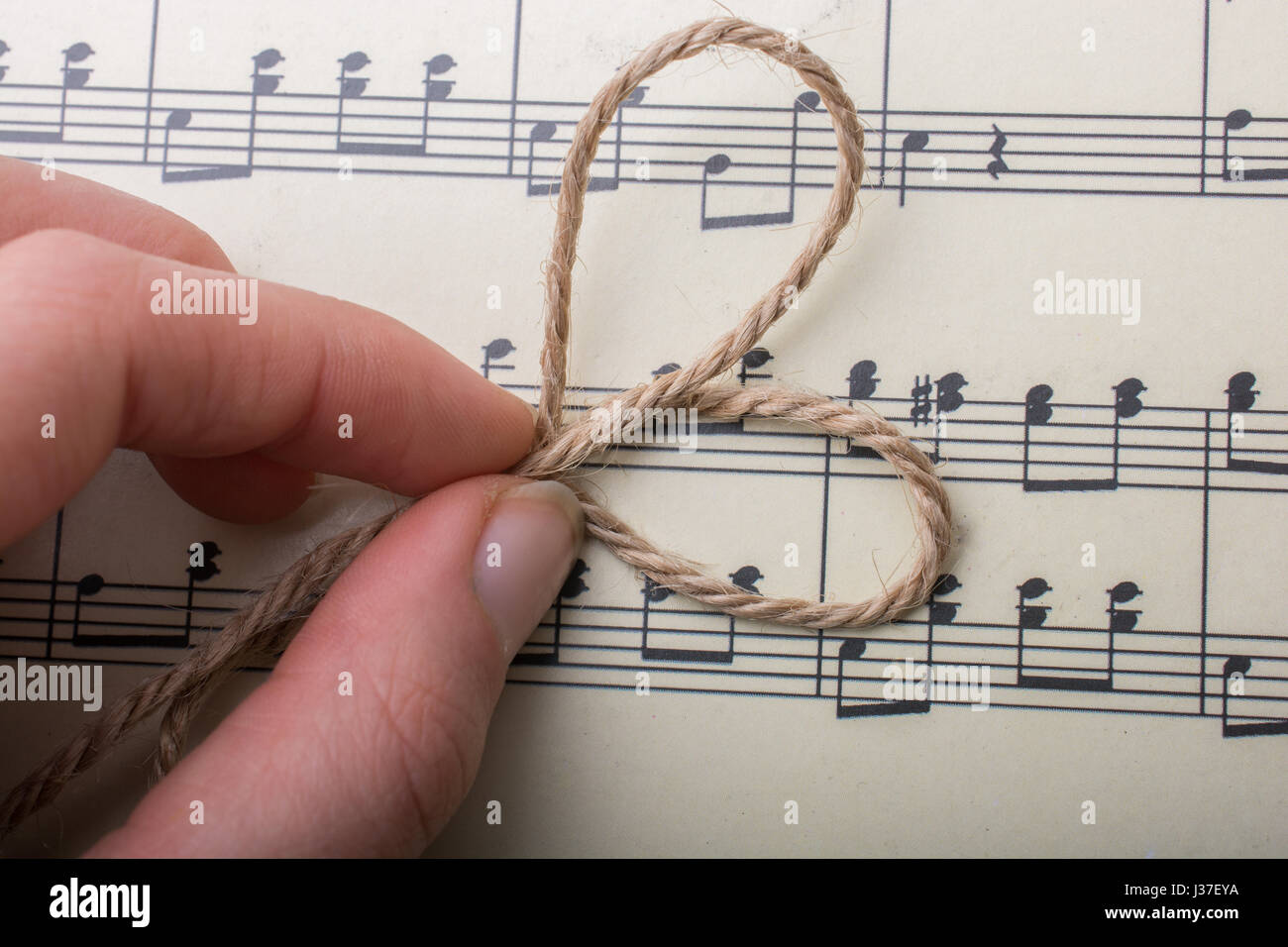 linen thread is placed on paper with musical notes Stock Photo - Alamy