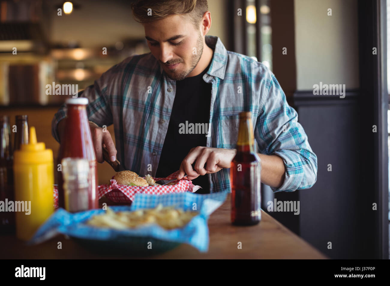 Man having burger at restaurant Stock Photo - Alamy