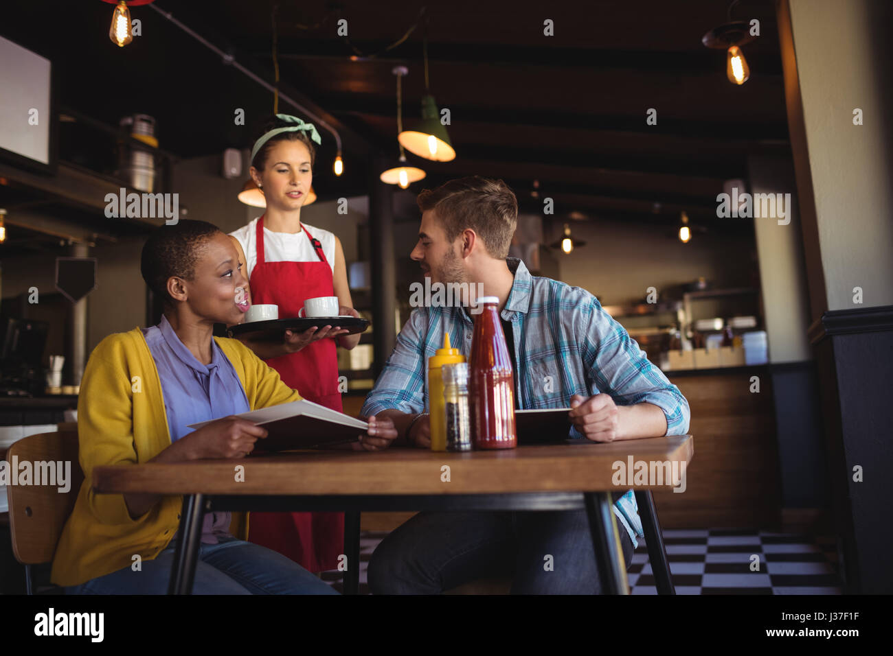 Waitress interacting with customer at restaurant Stock Photo - Alamy