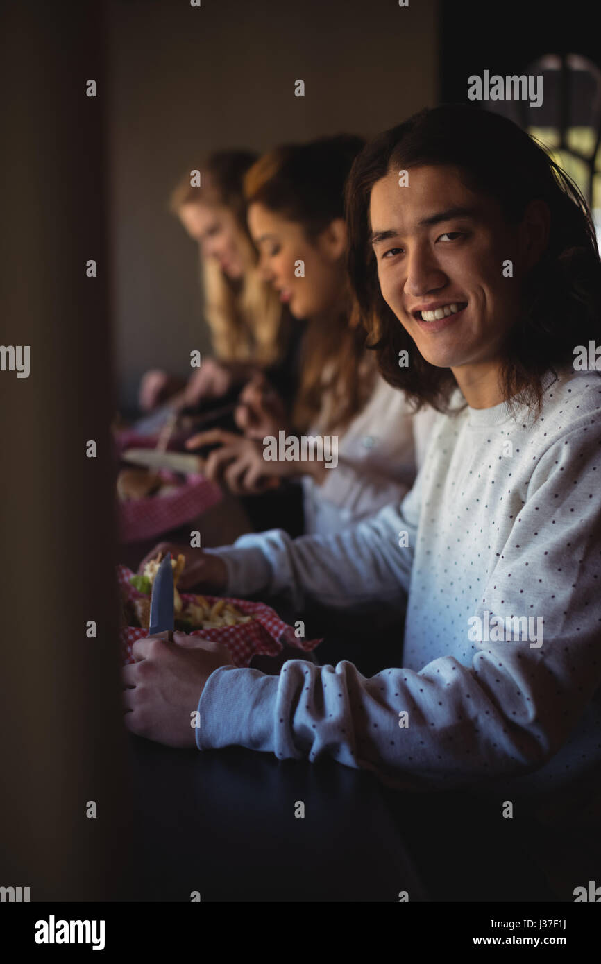 Friends having burger together at restaurant Stock Photo - Alamy
