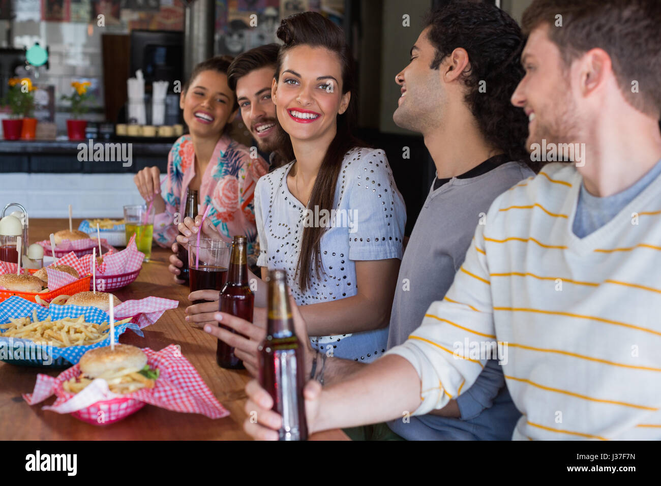 Portrait of happy friends having lunch in restaurant Stock Photo - Alamy