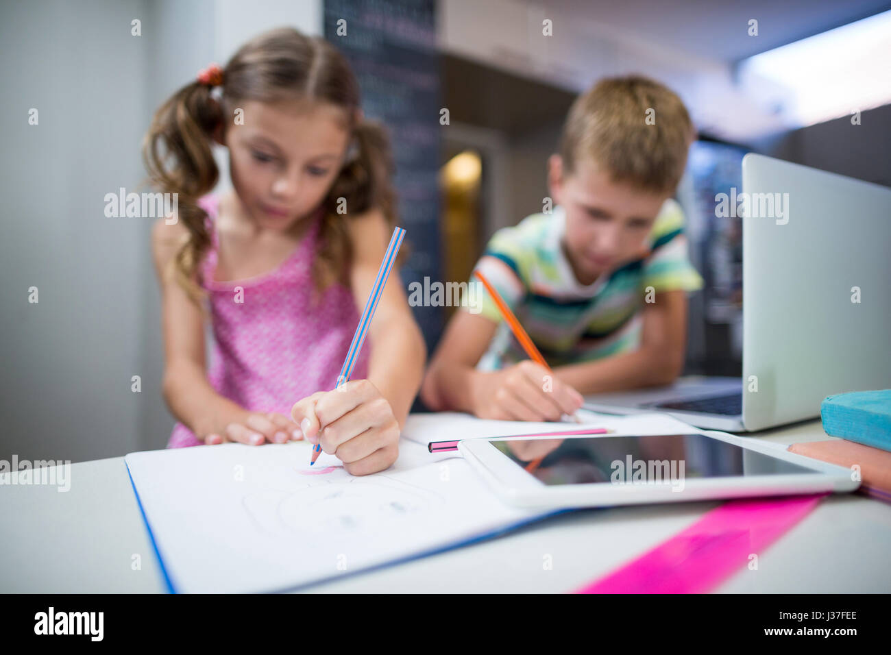 Siblings doing their homework in kitchen at home Stock Photo - Alamy