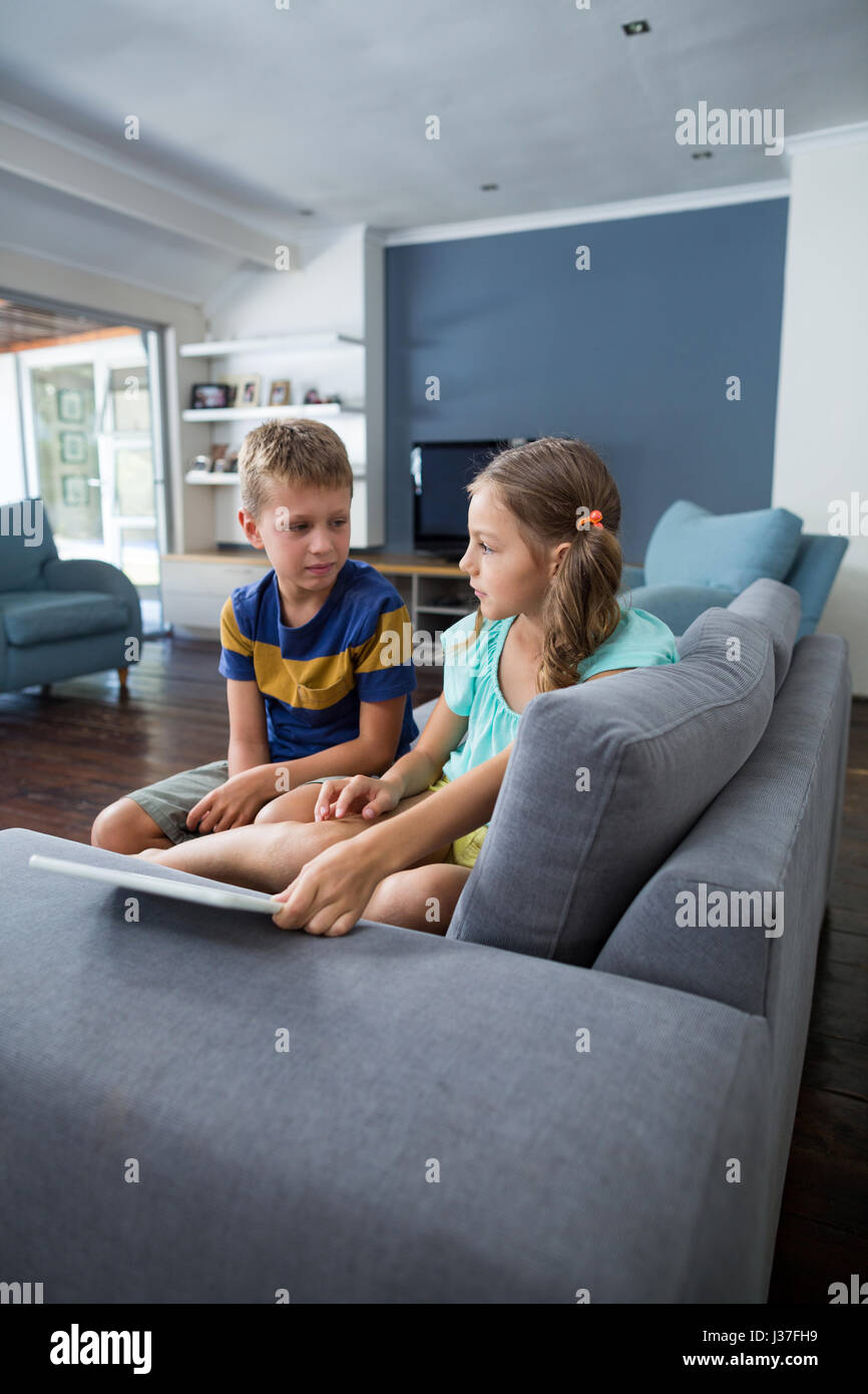Siblings interacting with each other in living room at home Stock Photo ...