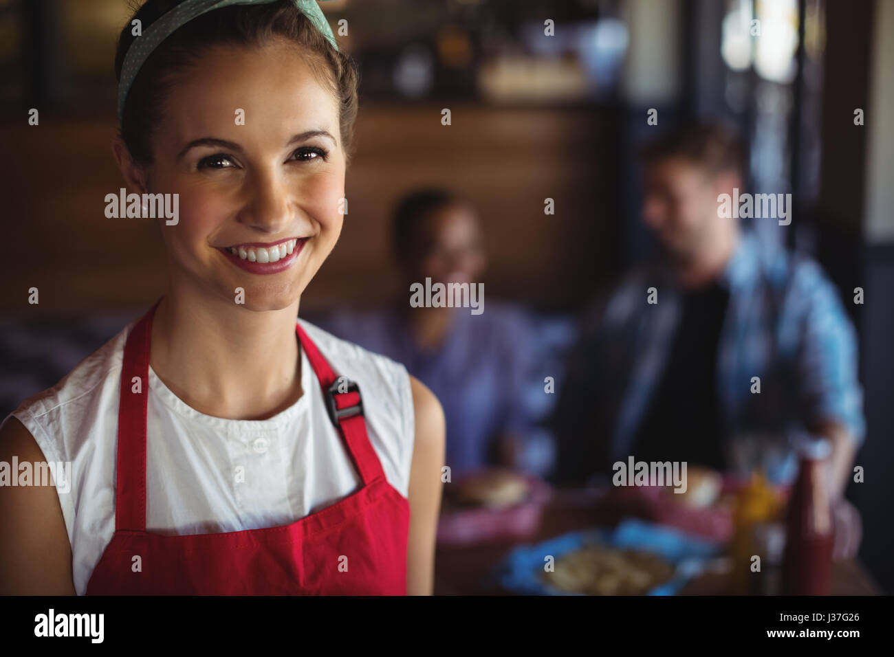 Portrait of smiling waitress at restaurant Stock Photo - Alamy