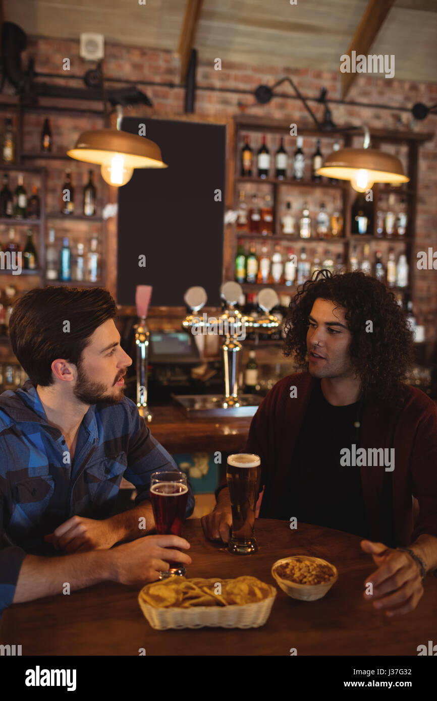 Happy friends having beer in pub Stock Photo - Alamy