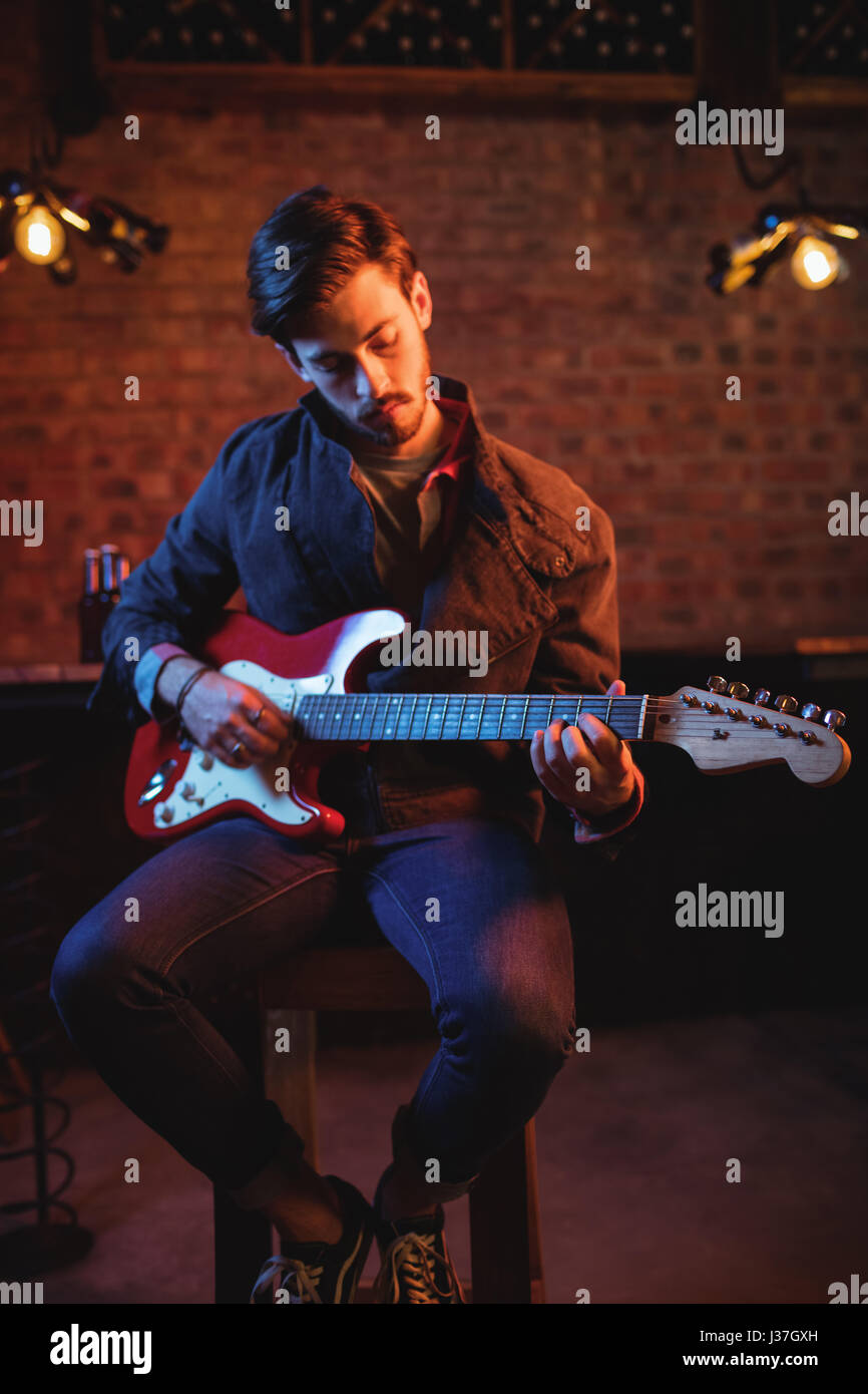 Young man playing guitar in pub Stock Photo - Alamy
