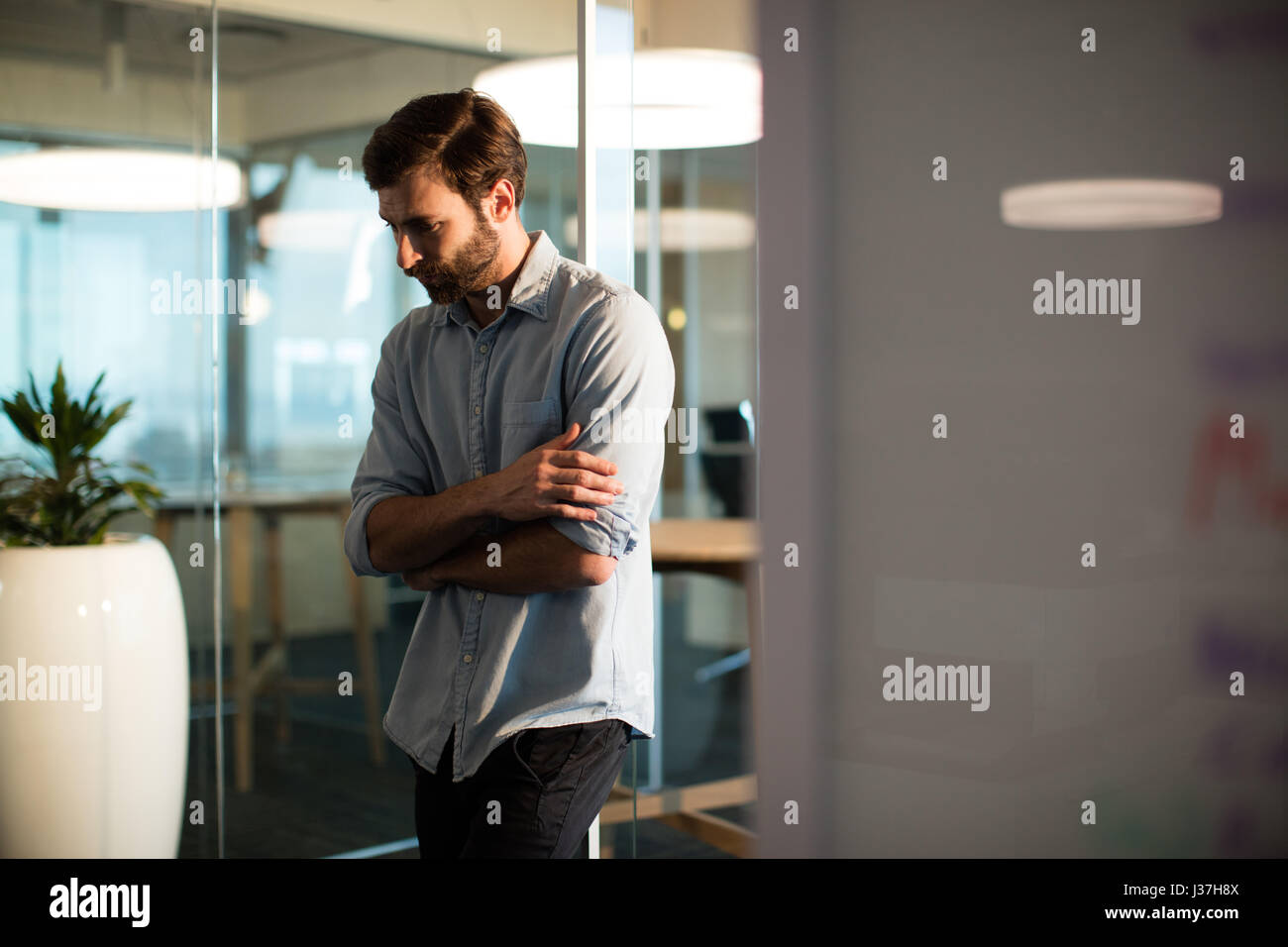 Lonely businessman looking down at office Stock Photo - Alamy