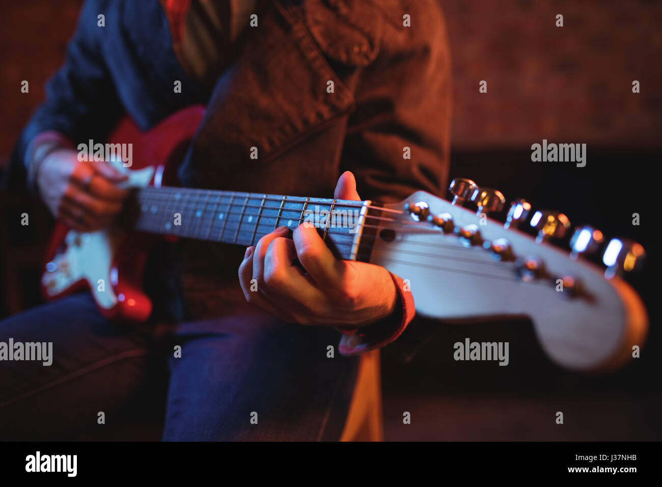 Mid-section of man playing guitar in pub Stock Photo - Alamy