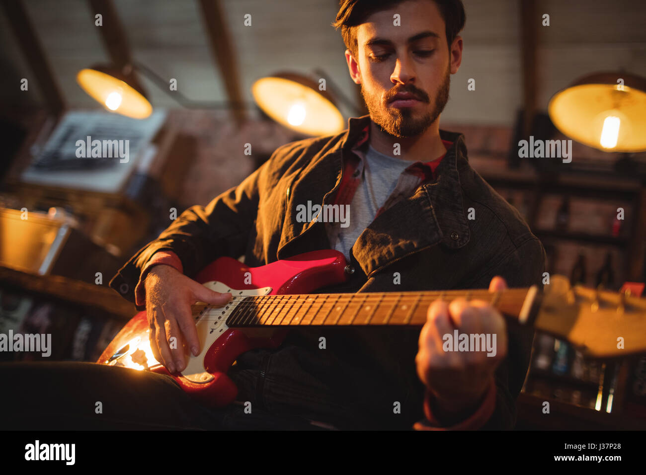 Young man playing guitar in pub Stock Photo - Alamy