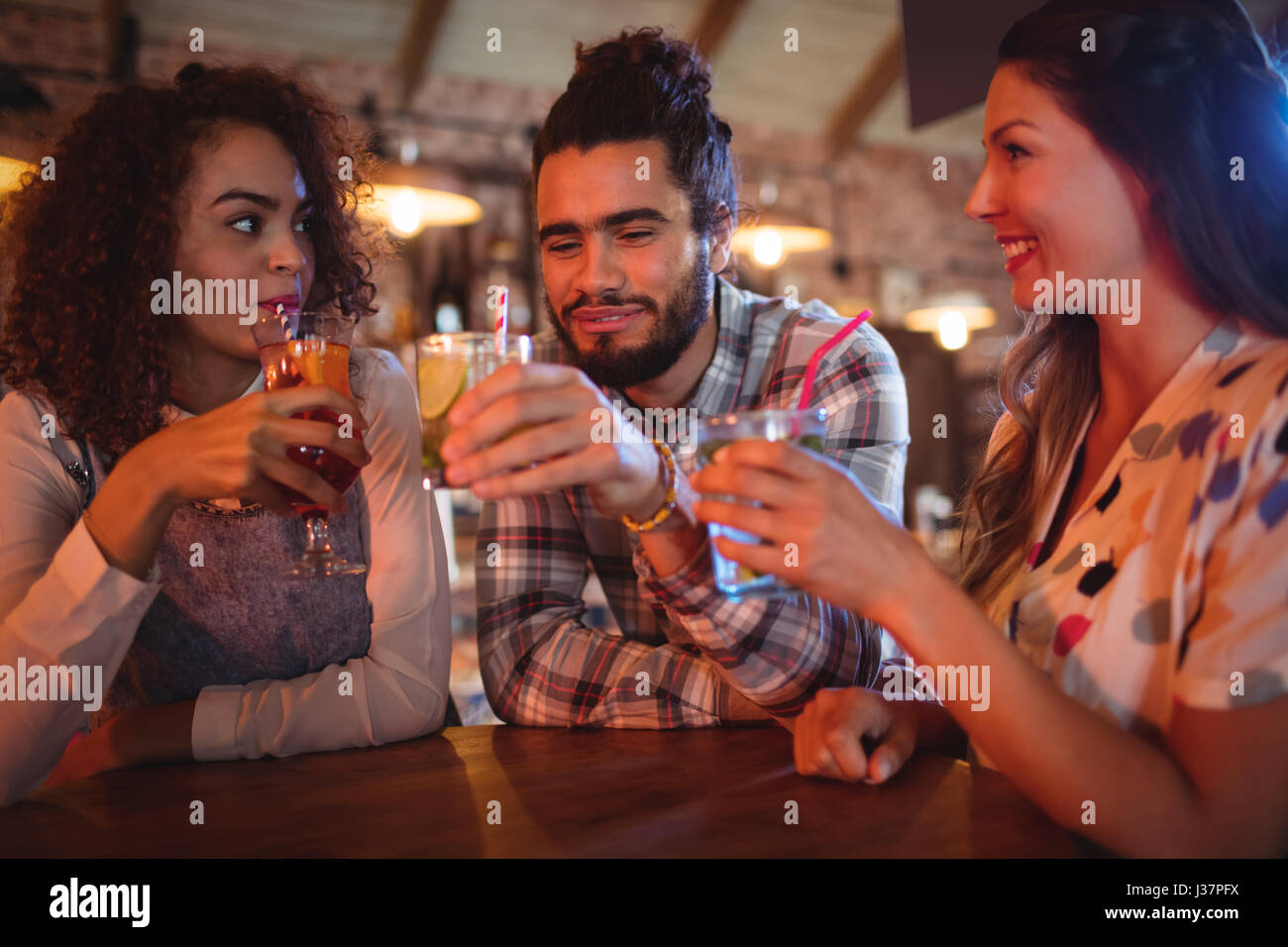 Young friends interacting with each other having drinks in pub Stock ...