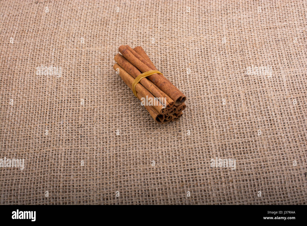 bundle of cinnamon sticks on a linen canvas background Stock Photo - Alamy