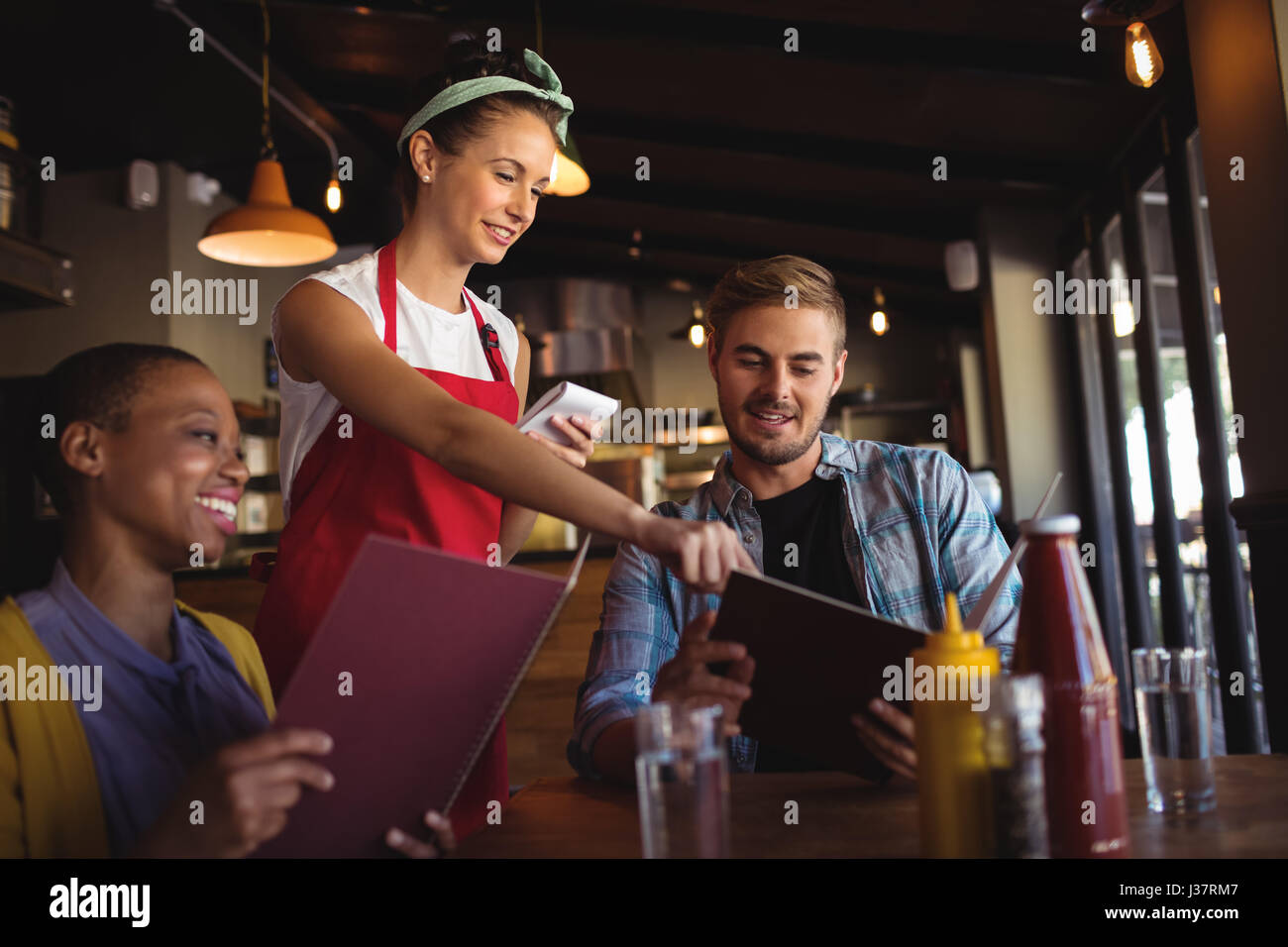 Beautiful waitress taking order at restaurant Stock Photo - Alamy