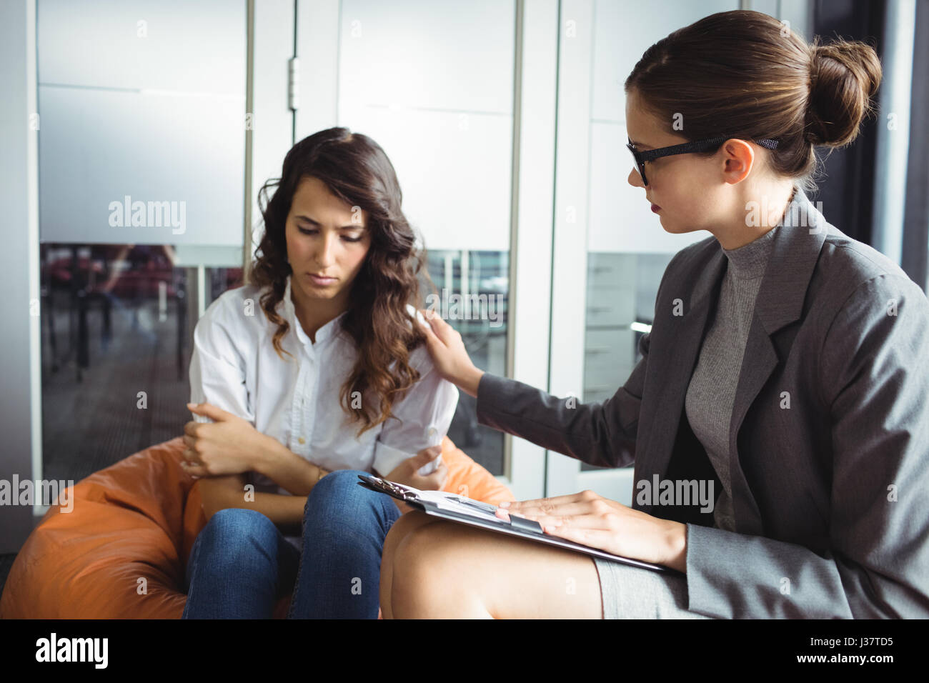 Counselor consoling unhappy woman during therapy Stock Photo - Alamy