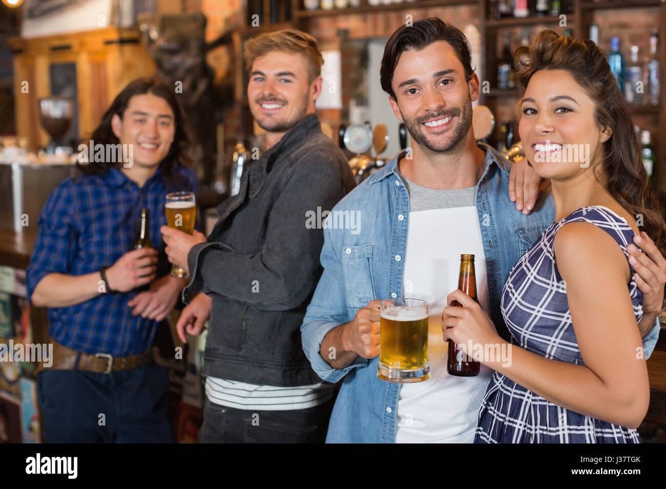 Portrait of smiling friends with beer bottles and glasses in pub Stock ...
