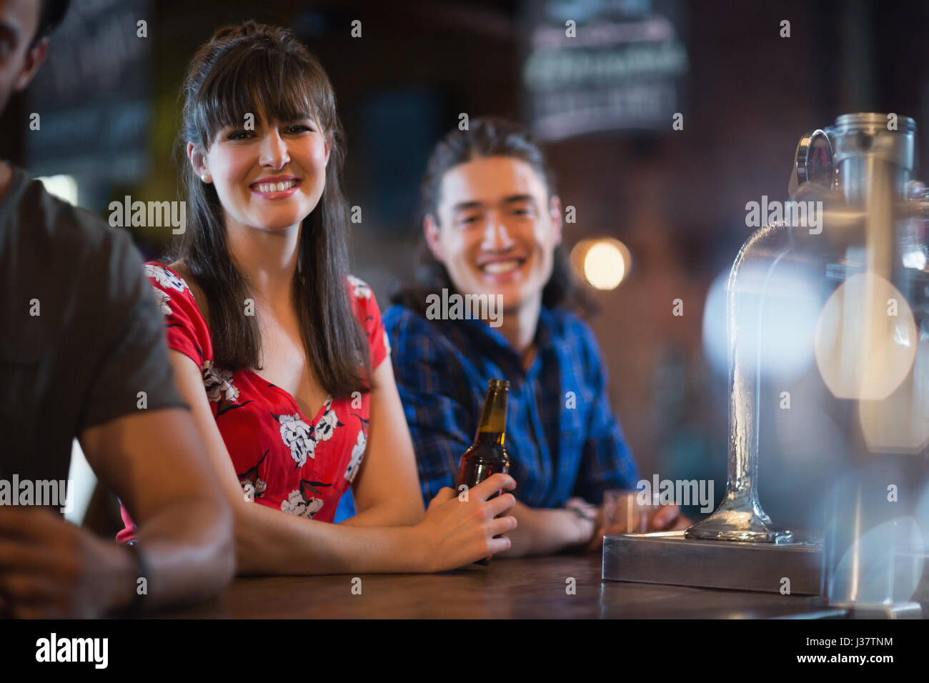 Portrait of smiling friends leaning at counter in bar Stock Photo - Alamy