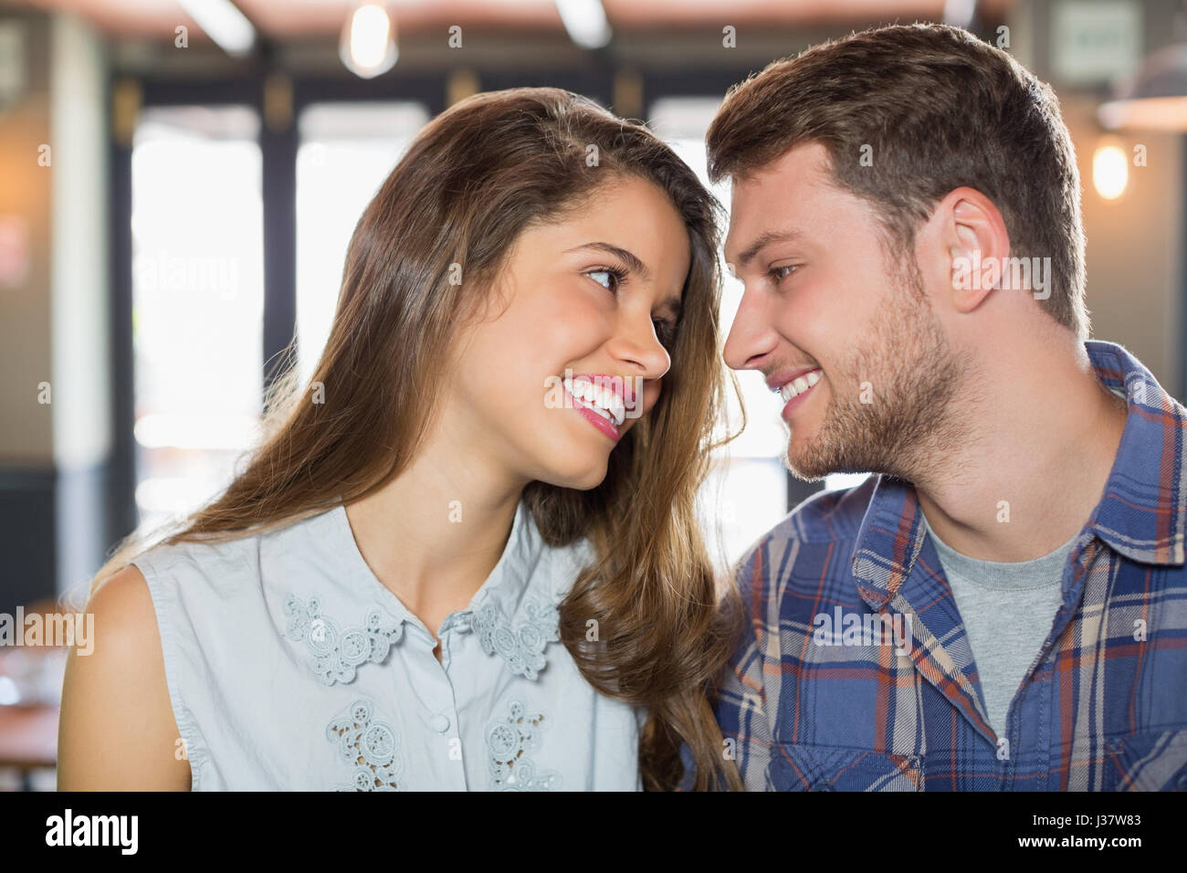 Close up of young friends looking at each other in restaurant Stock ...