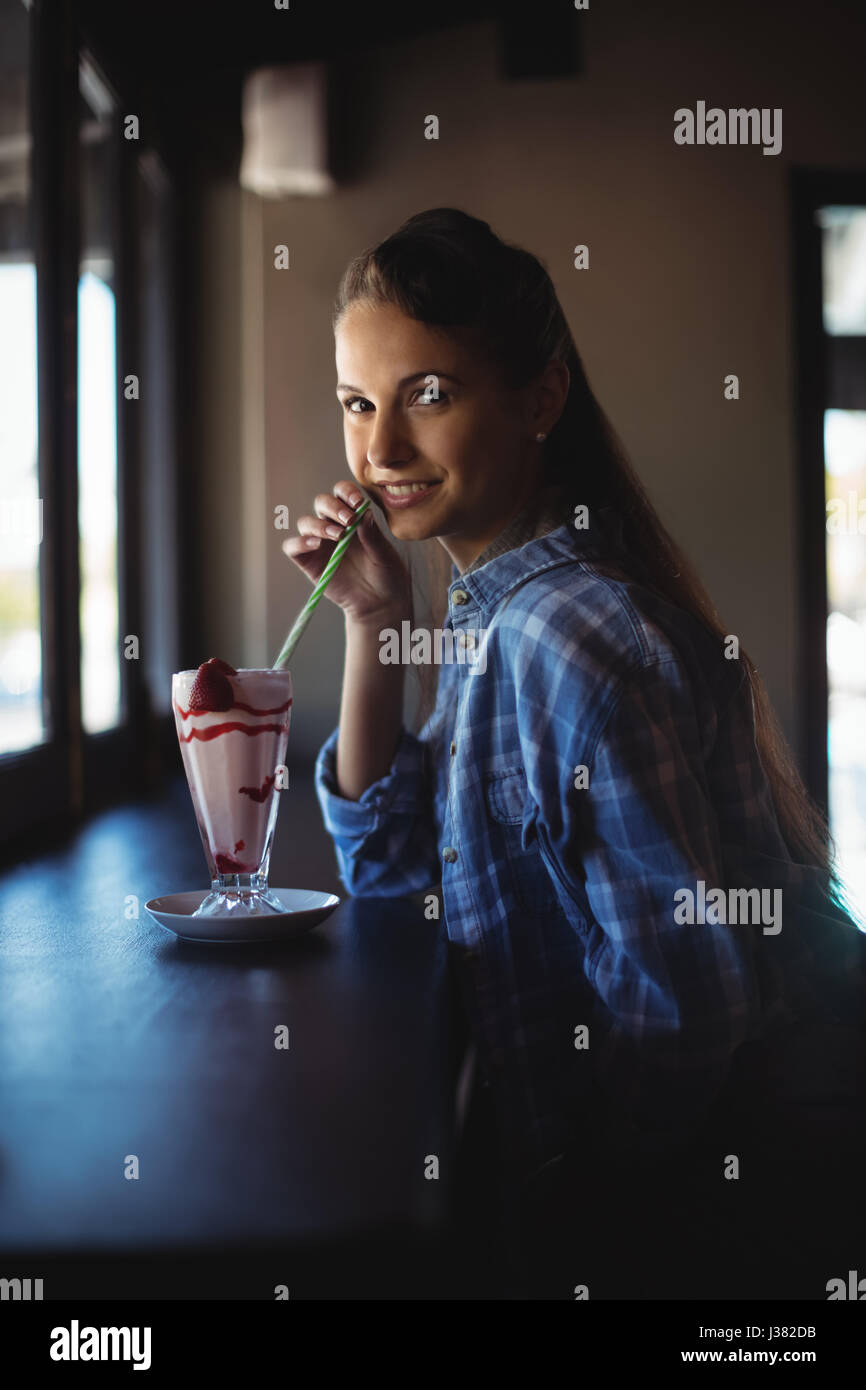 Portrait of beautiful woman having milkshake in restaurant Stock Photo ...