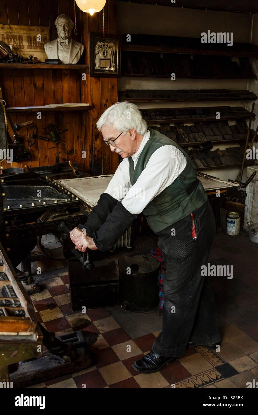 A man in period costume works a traditional printing press at Blists ...