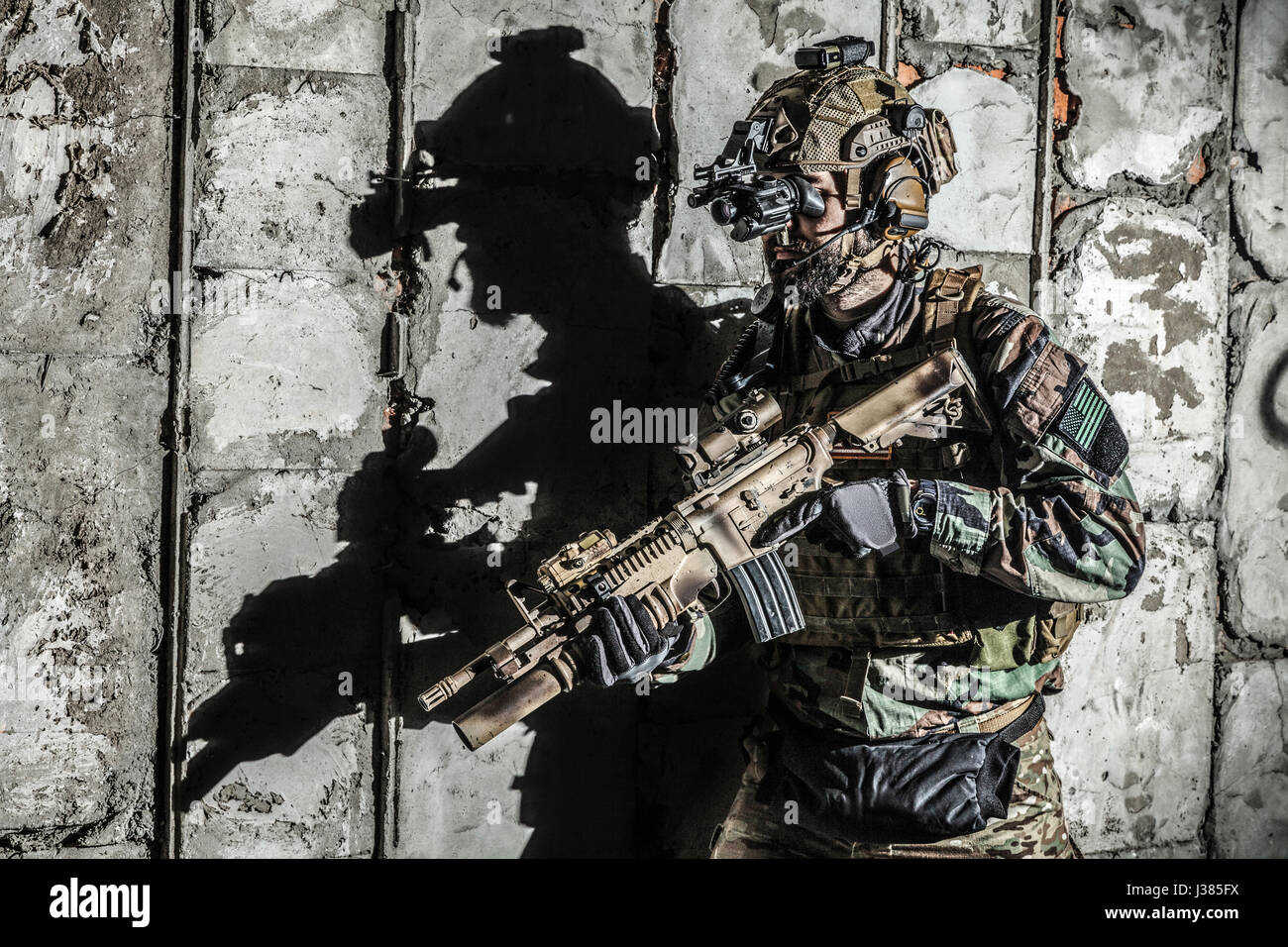Army Ranger moving along the concrete wall with his black shadow Stock ...