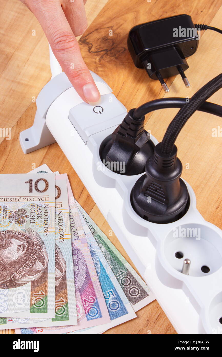 Finger of woman turns off electrical power strip with connected plug ...