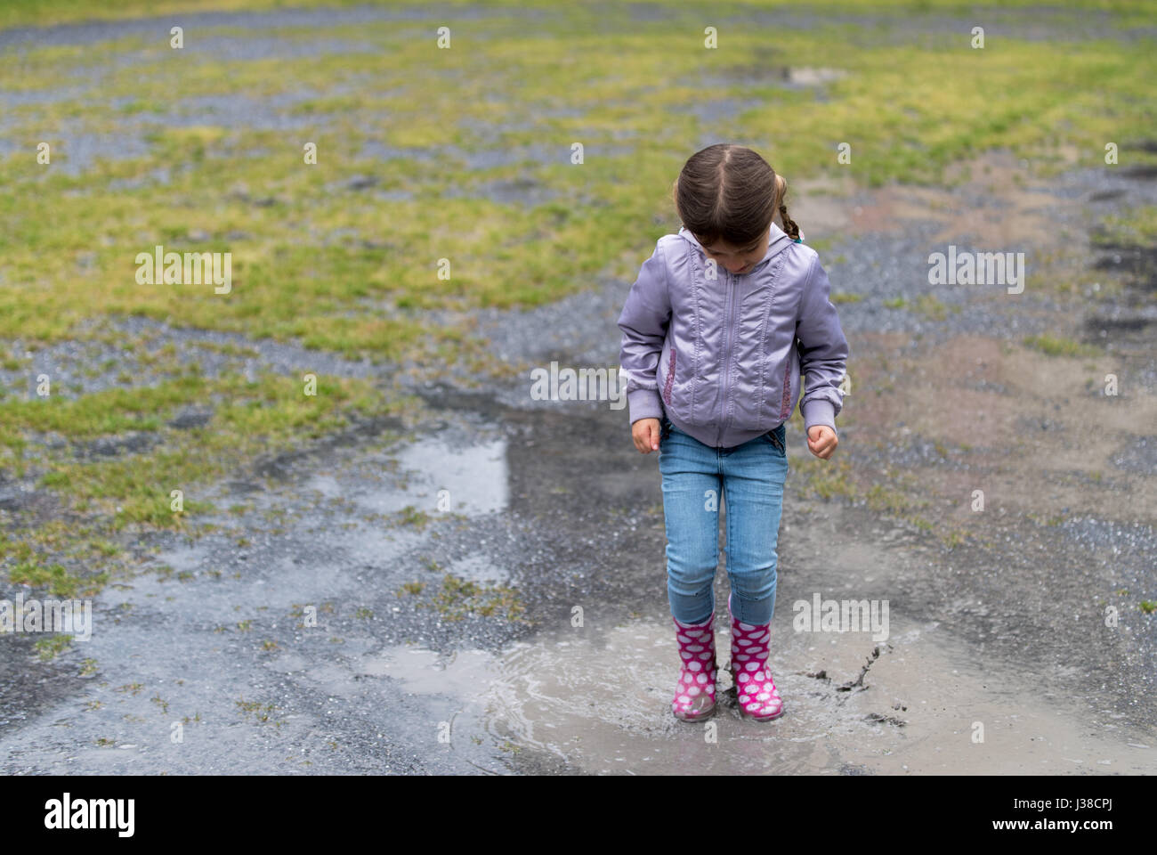 Girl jumping in the puddle Stock Photo - Alamy