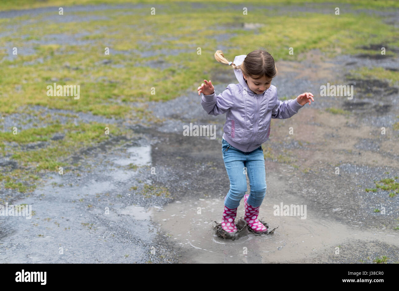 Girl jumping in the puddle Stock Photo - Alamy