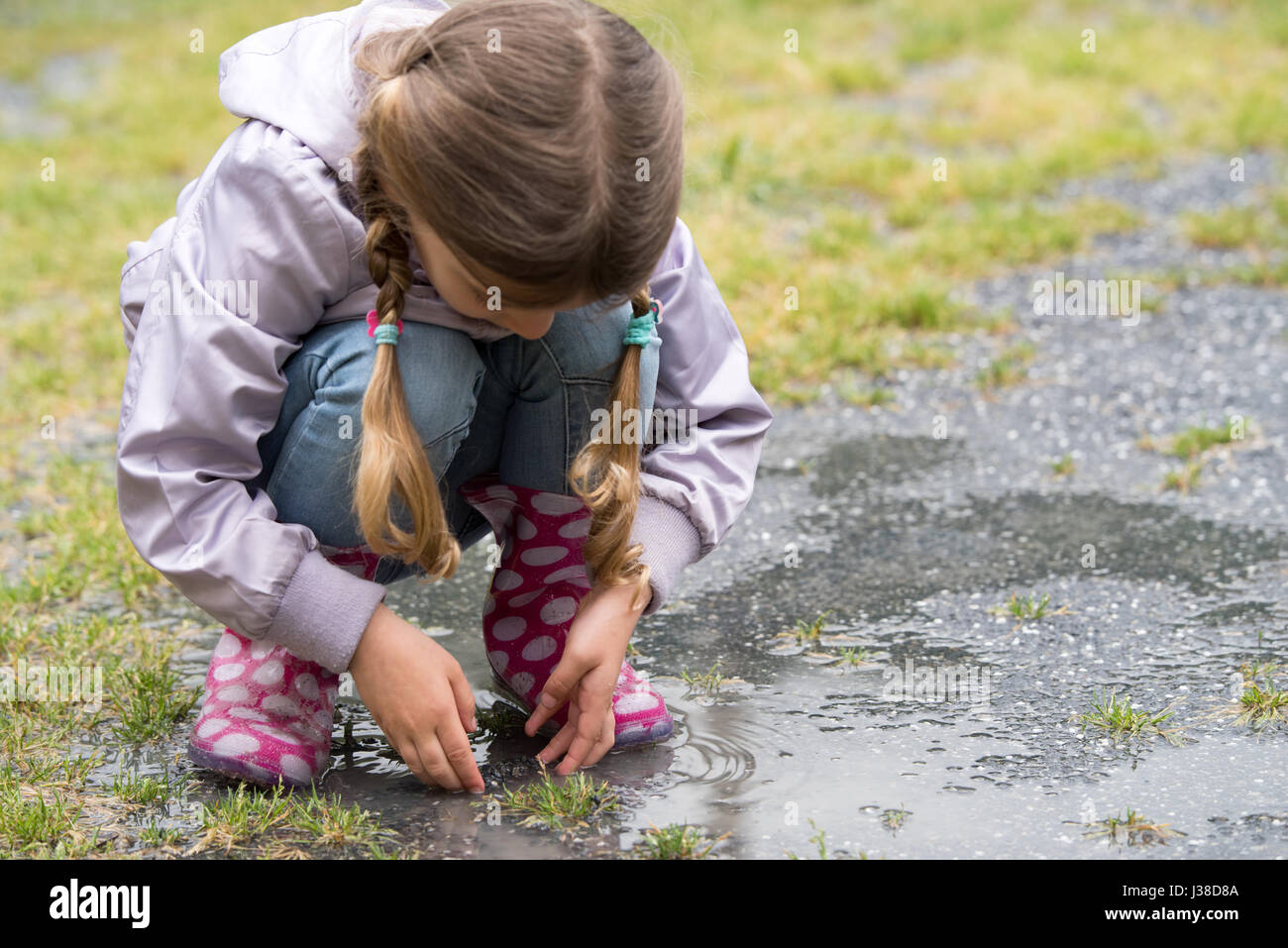 Little girl playing in the rain Stock Photo - Alamy