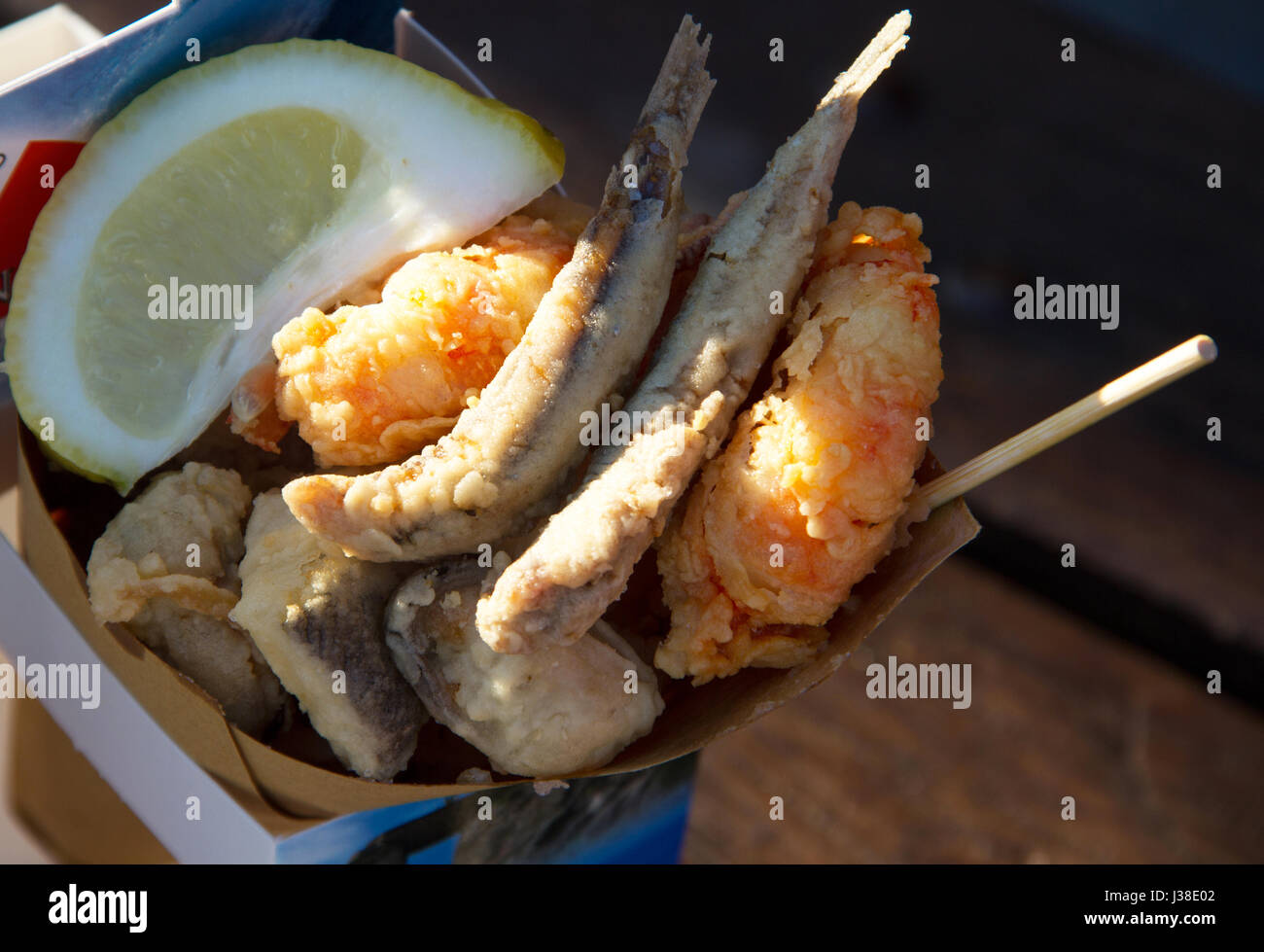 Fried fish in a newspaper cone with lemon Stock Photo - Alamy