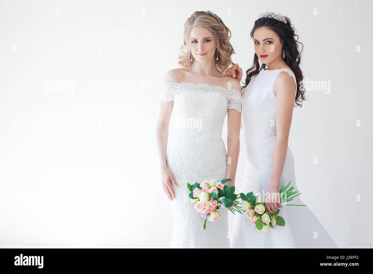 two brides in white wedding gowns Stock Photo - Alamy