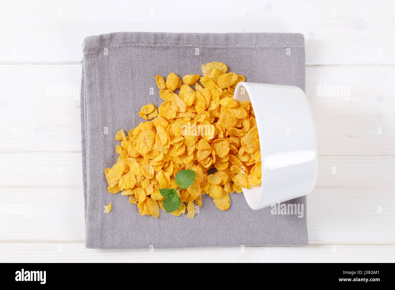 pile of corn flakes spilt out on grey place mat Stock Photo - Alamy