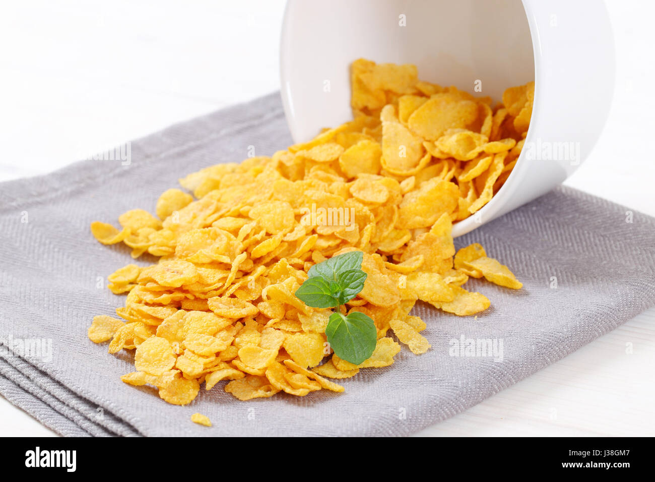 pile of corn flakes spilt out on grey place mat - close up Stock Photo ...