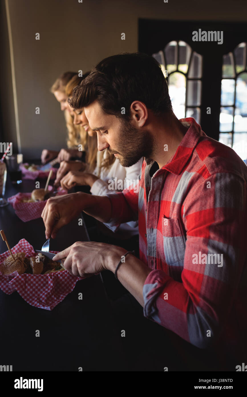 Friends having burger together at restaurant Stock Photo - Alamy