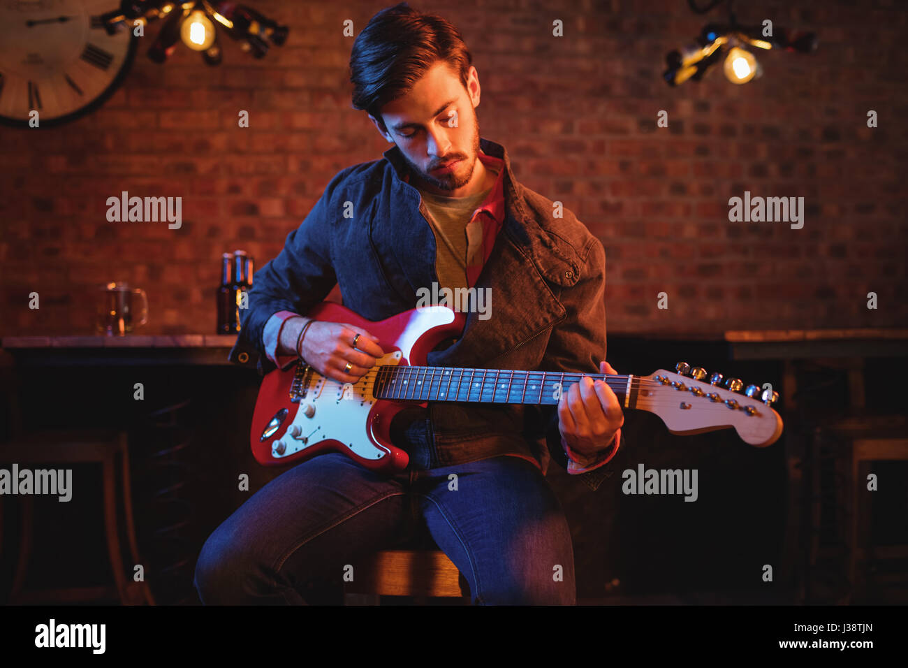 Young man playing guitar in pub Stock Photo - Alamy