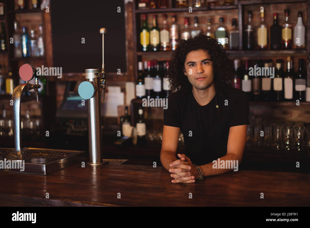 Portrait of male bar tender at bar counter Stock Photo - Alamy