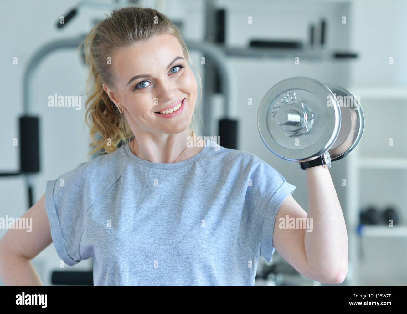 Young woman in a gym with a dumbbell Stock Photo - Alamy