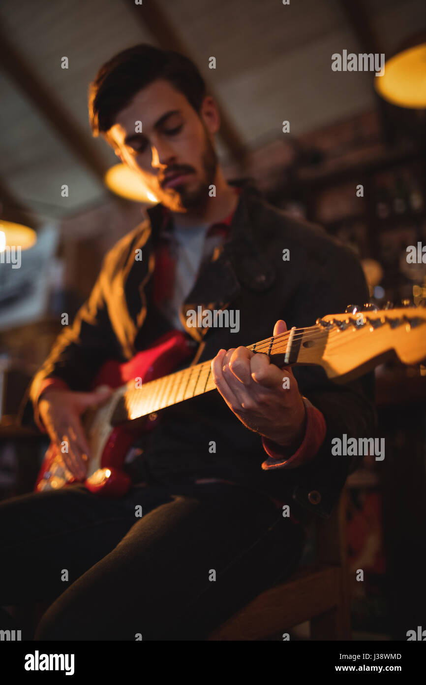 Young man playing guitar in pub Stock Photo - Alamy
